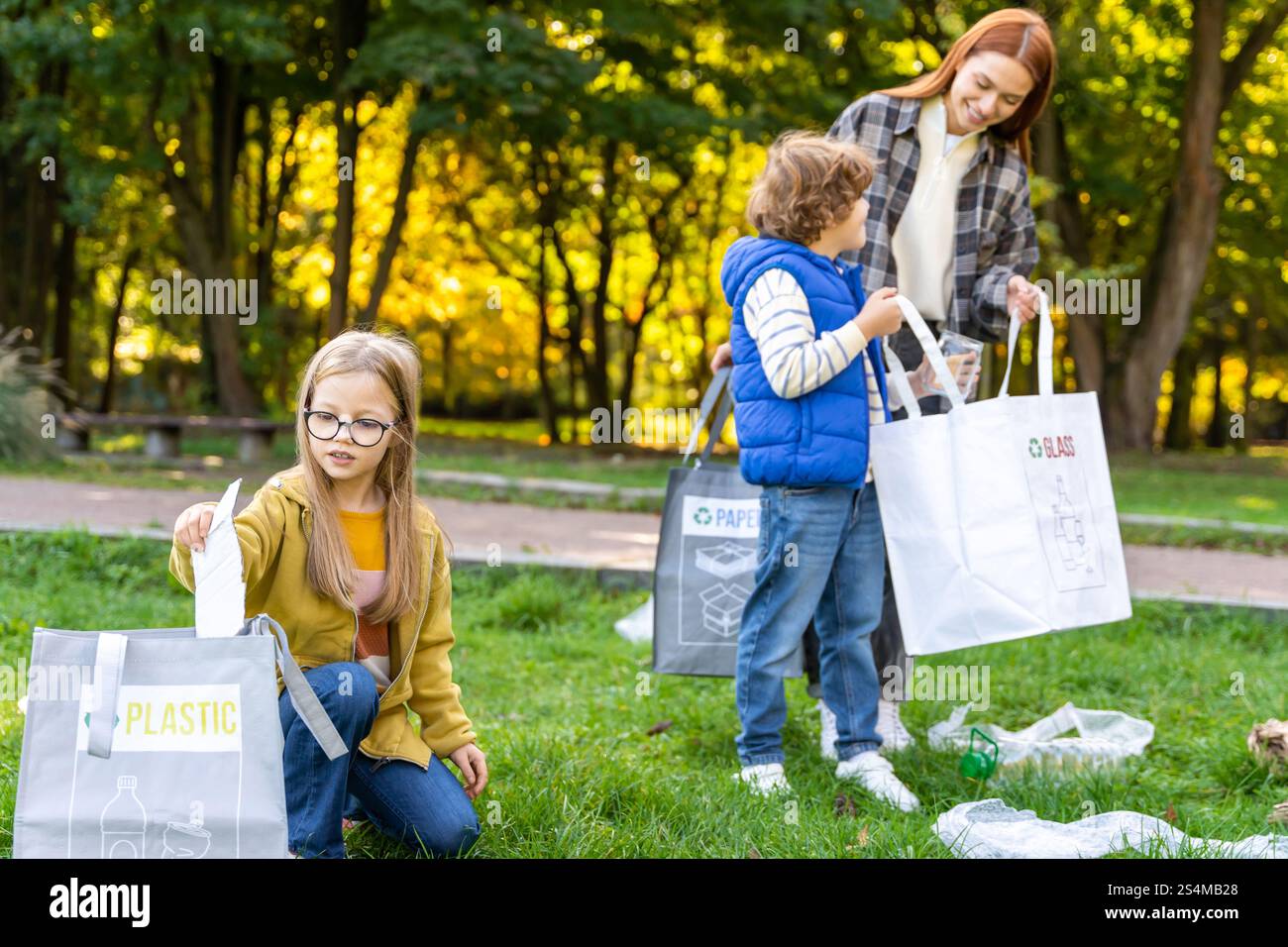 Kids with teacher collecting garbage in park working in volunteers ...