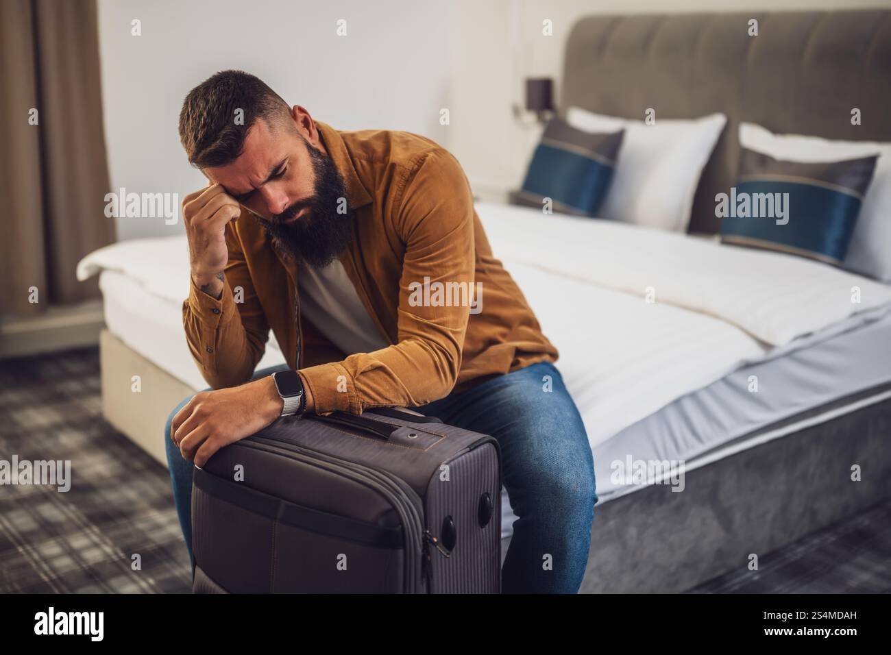 Tourist arrived in hotel room with her suitcase. He is tired of travel ...