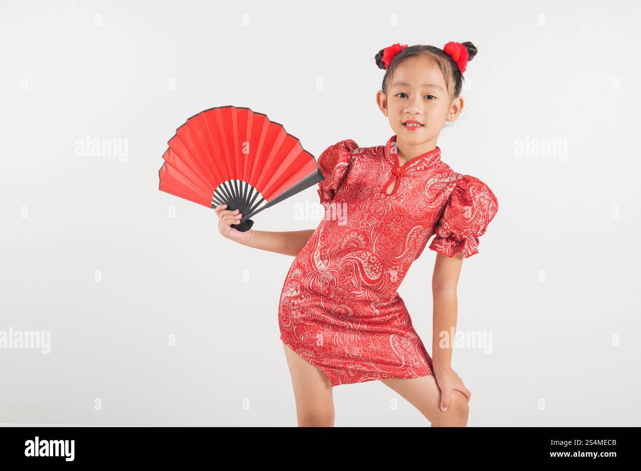 Child in traditional red cheongsam smiling and holding a fan. Isolated ...