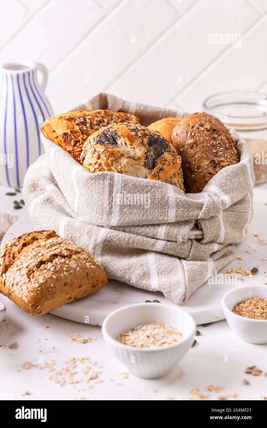 Variation of bread rolls or buns in breadbag with butter and assorted ...