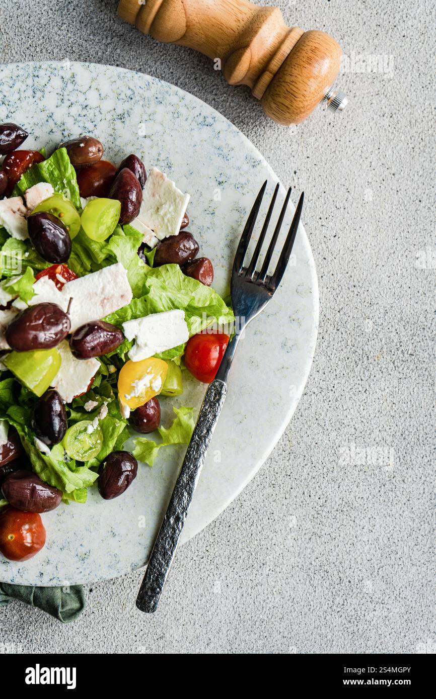 A vibrant Greek salad with tomatoes, lettuce, red olives, and feta ...