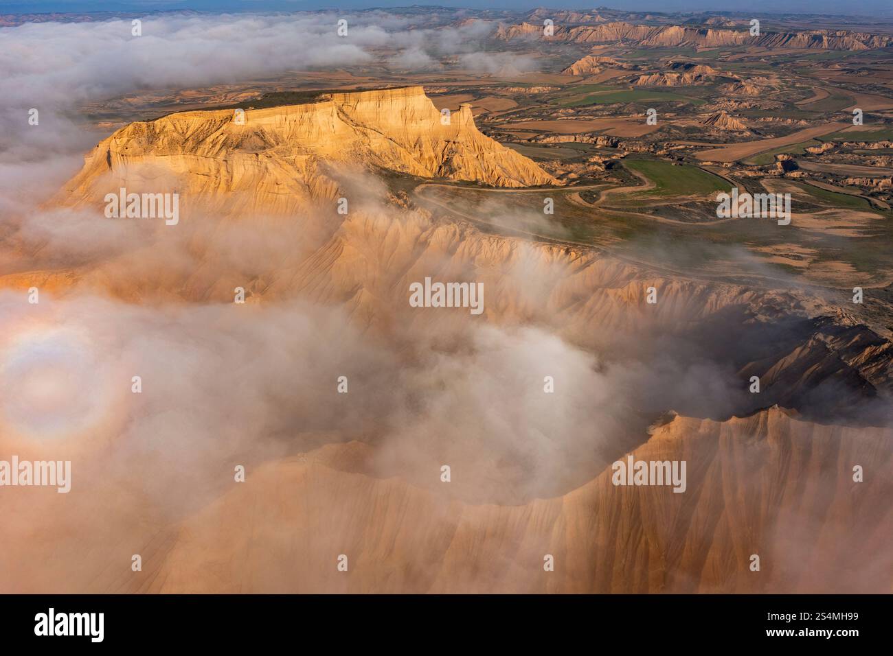 A stunning aerial view of rugged desert cliffs partially shrouded in ...