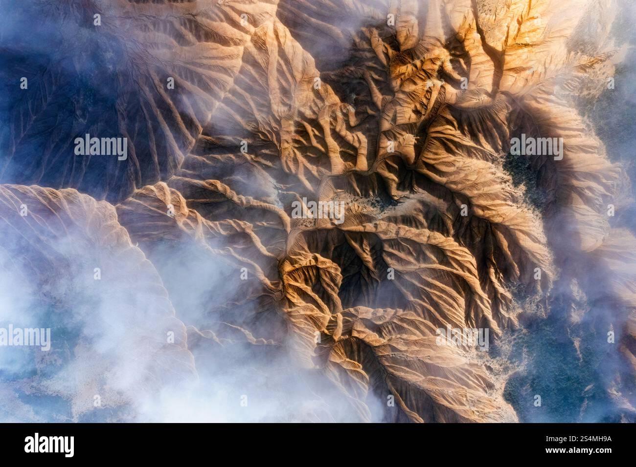 An aerial view showcases rocky mountain formations with deep ridges and ...