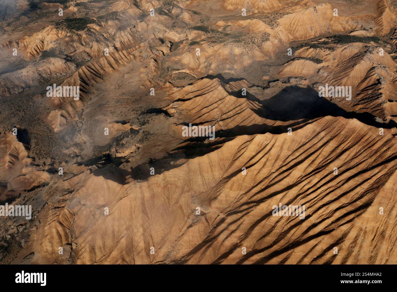 Aerial view depicting rugged desert terrain marked by dramatic ridges ...