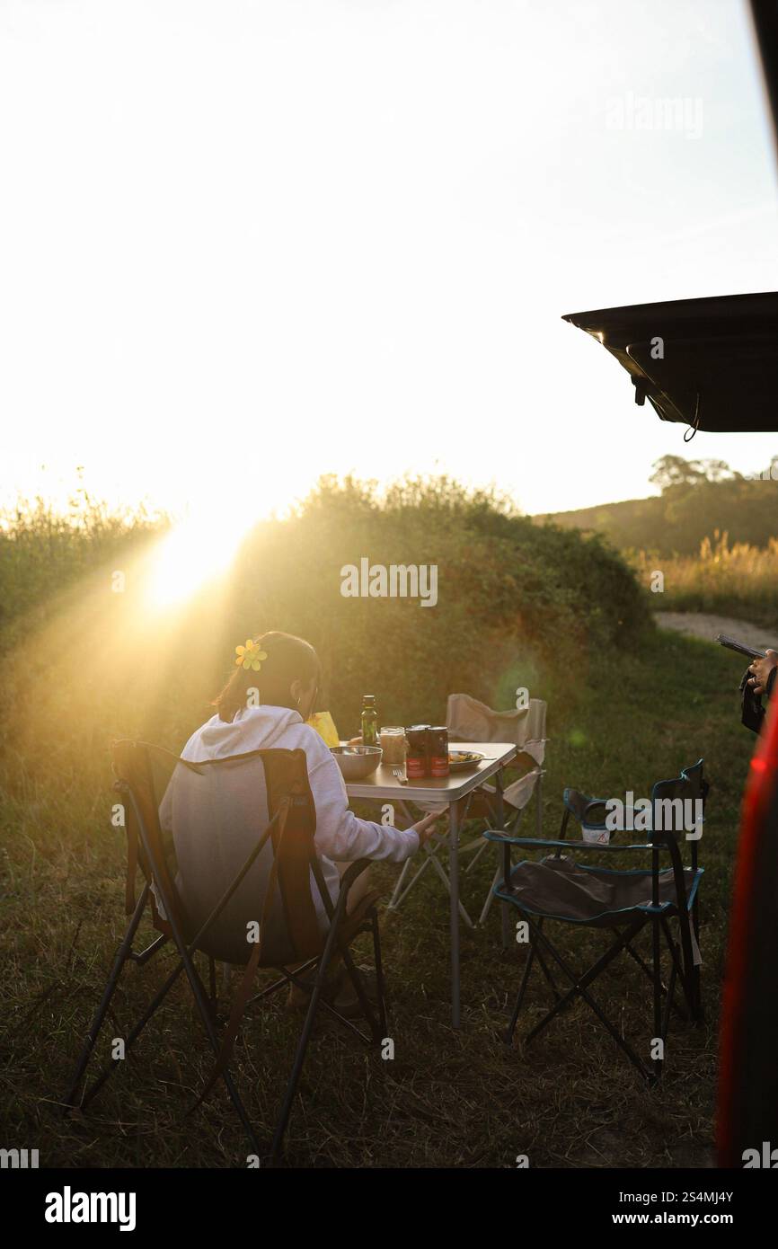 A peaceful outdoor dining setup during sunset, featuring a person ...