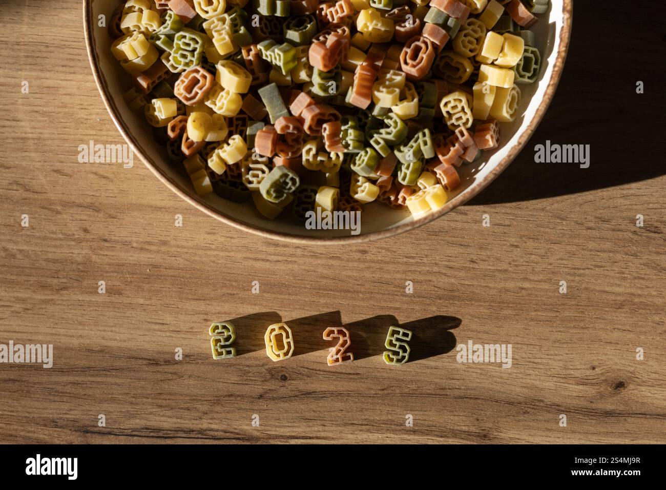 Top view of colorful number shaped pasta in a bowl and the number 2025 ...