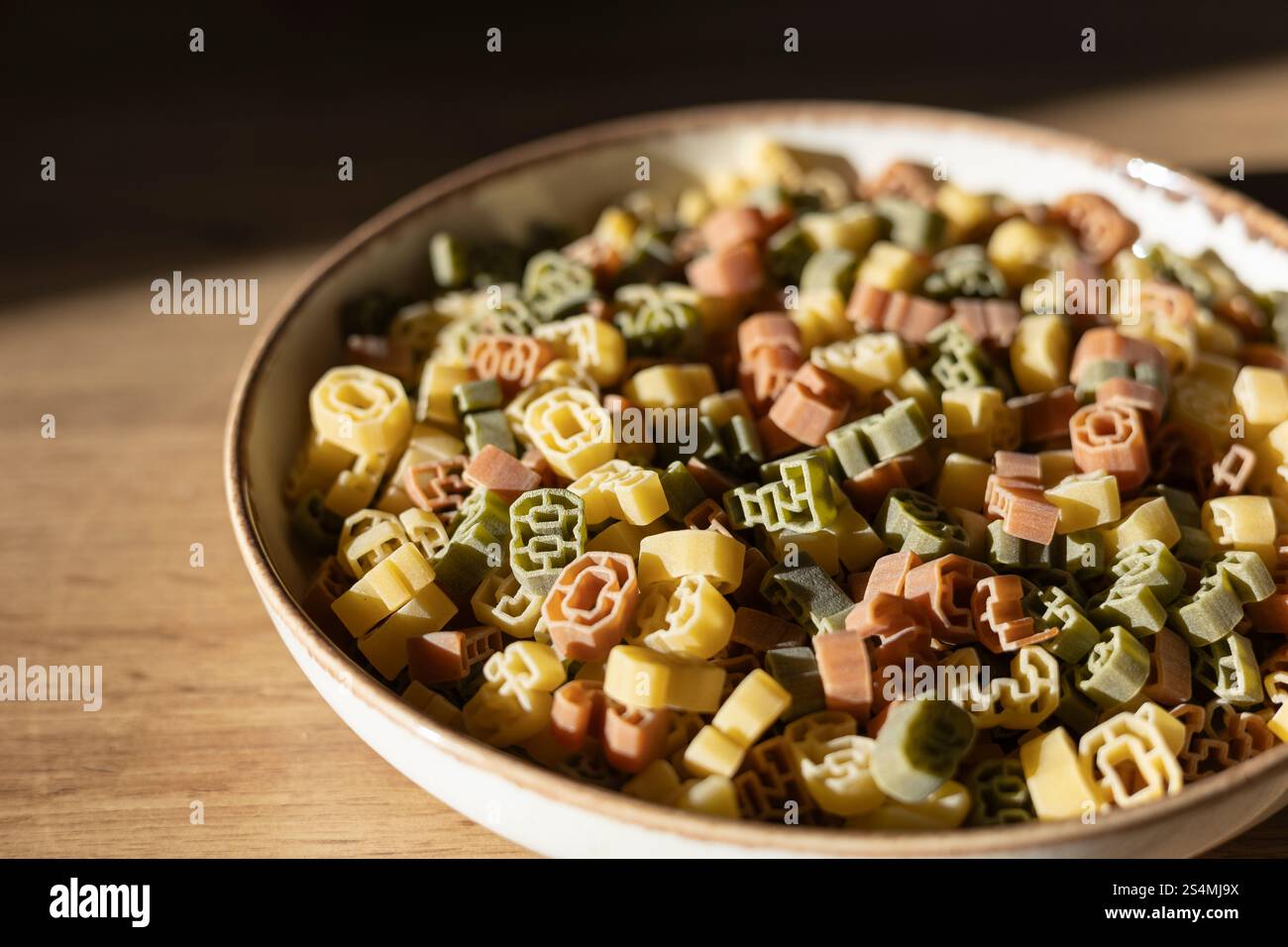 Ceramic bowl filled with multicolored number shaped pasta, clearly ...