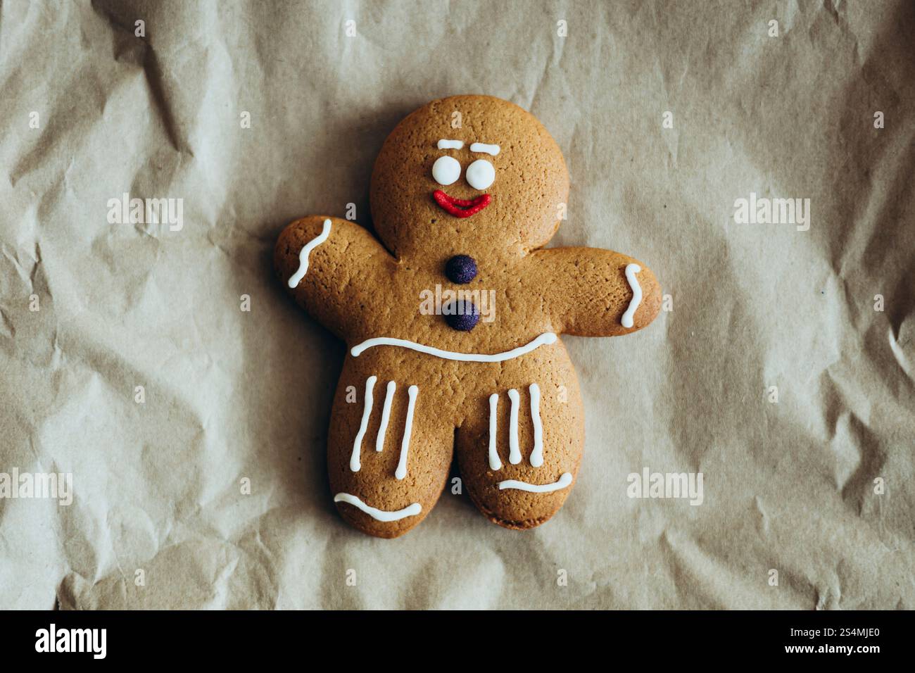 A festive gingerbread man cookie decorated with icing, lying on a ...