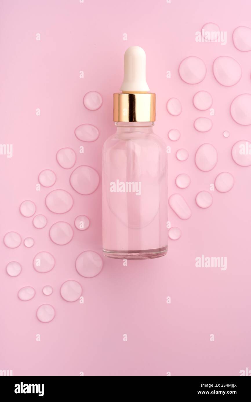 A clear glass dropper bottle on a pink background, surrounded by ...