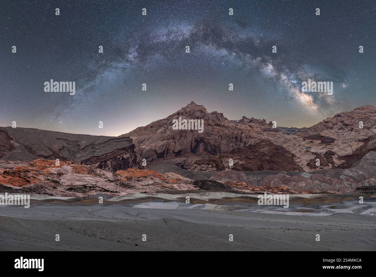 A breathtaking panoramic view of the Milky Way arching over the rugged ...