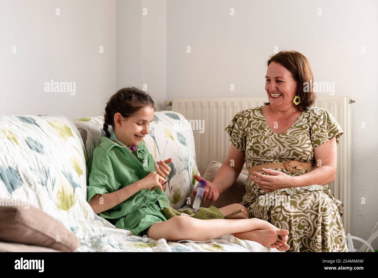 A family scene featuring a smiling young girl with a tracheostomy ...