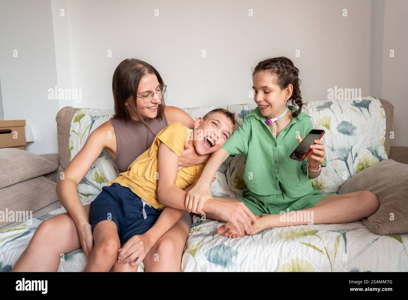 A loving family spends quality time on the couch. The girl with a ...