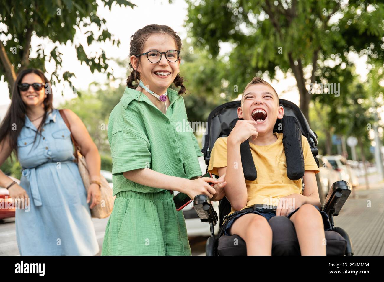 A joyful family outing shows a girl with a tracheostomy and a boy with ...