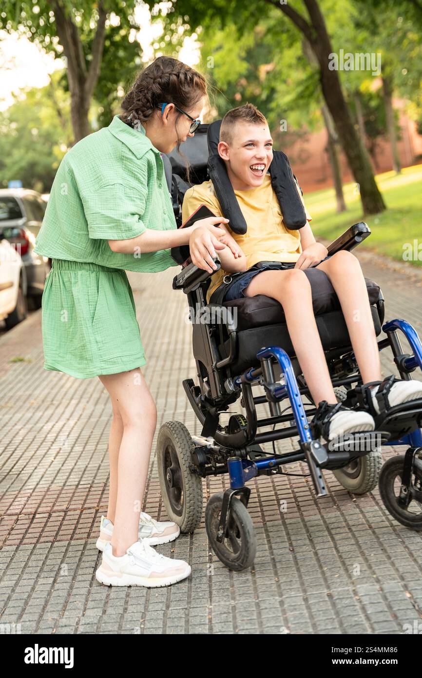 A cheerful girl with a tracheostomy supports her friend with cerebral ...