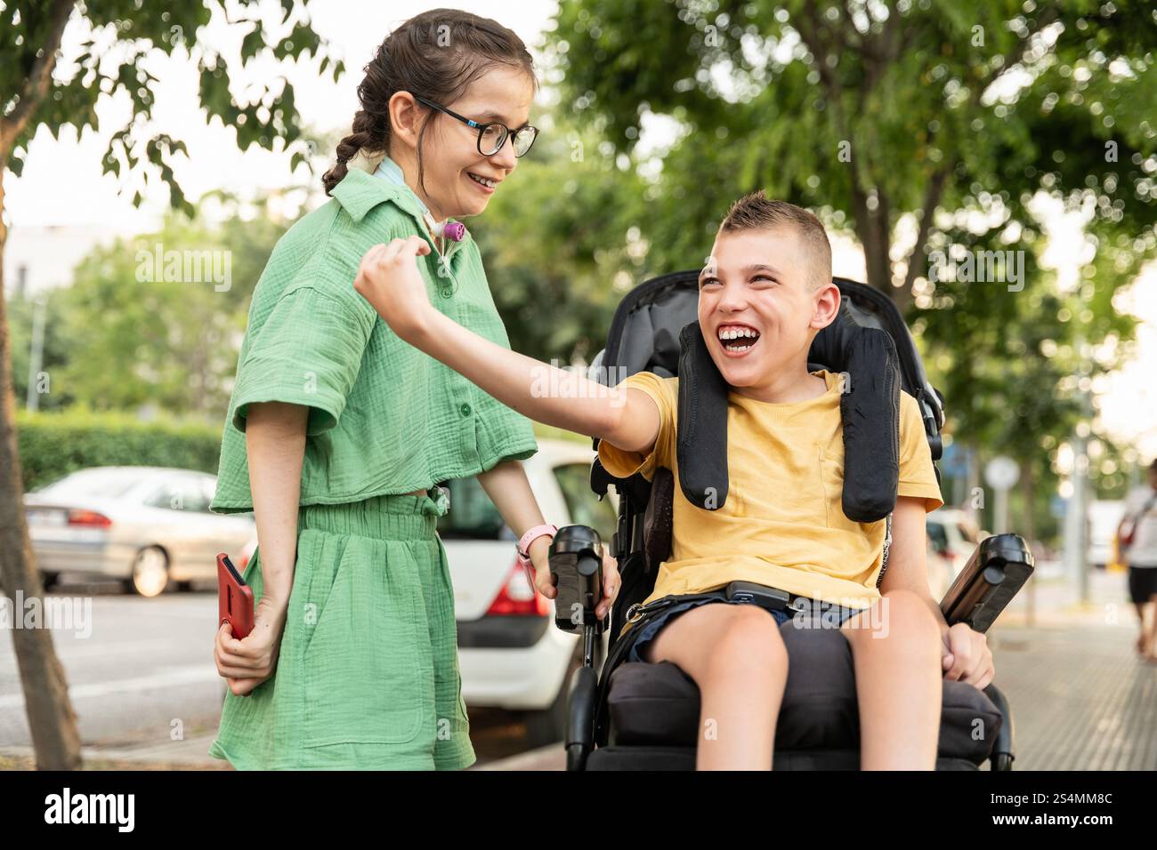 A boy with cerebral palsy in a wheelchair and a girl with a ...