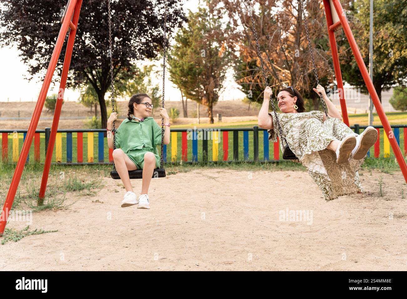 A family enjoys a sunny day at the park, focusing on a girl with a ...