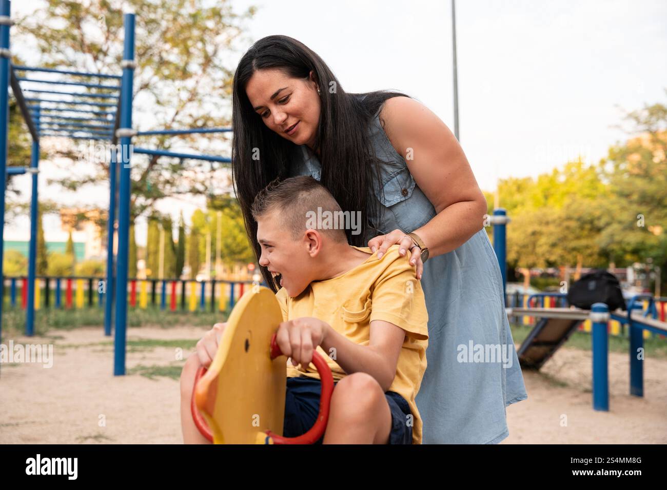 A mother lovingly supports her disabled son with cerebral palsy as they enjoy playtime at the ...