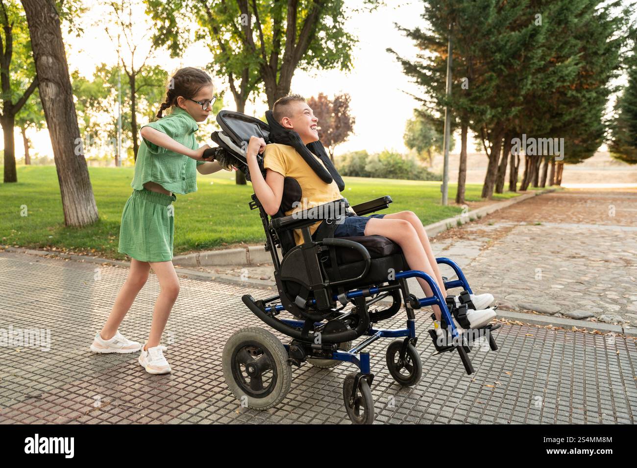 Two friends, a boy with cerebral palsy in a wheelchair and a girl with ...