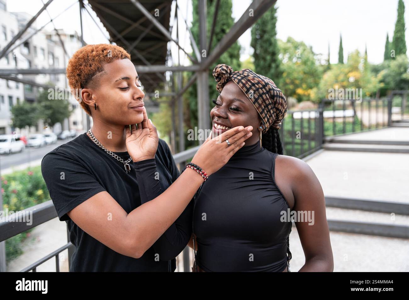A joyful LGBT multiethnic couple shares a tender moment outdoors ...