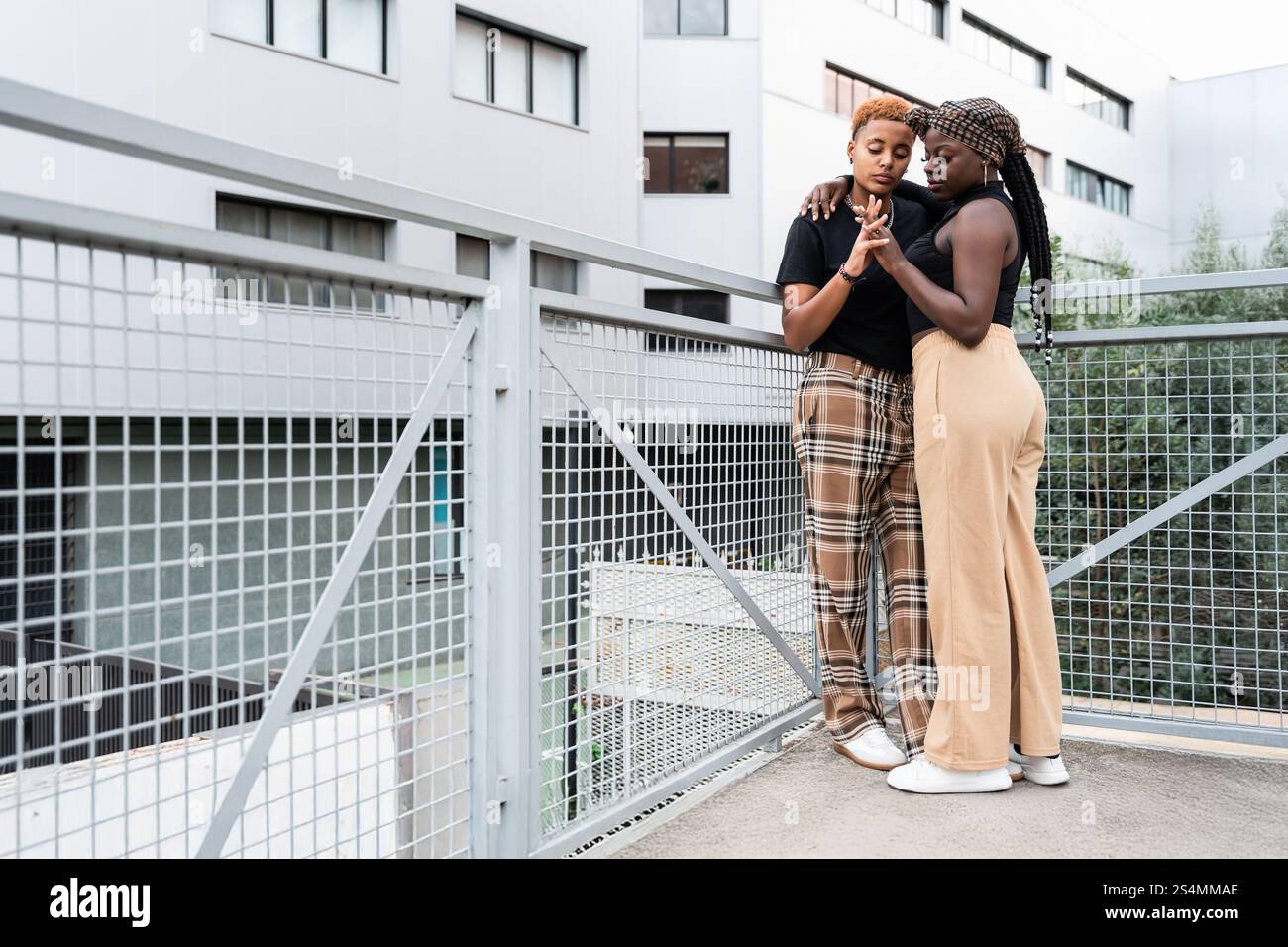 A loving LGBT multiethnic couple embraces tenderly on an outdoor ...