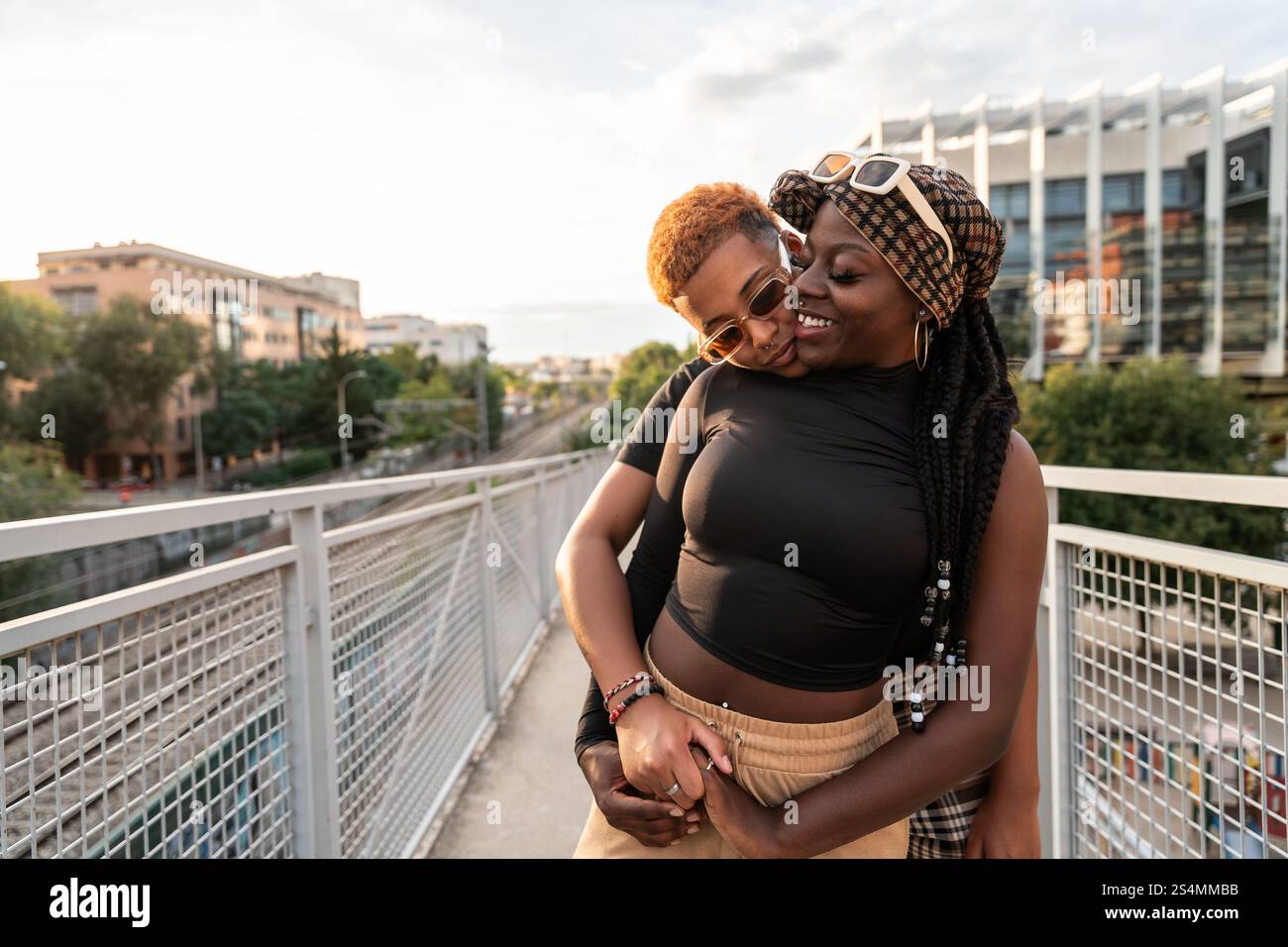 A happy LGBT multiethnic couple embraces and smiles warmly at each ...