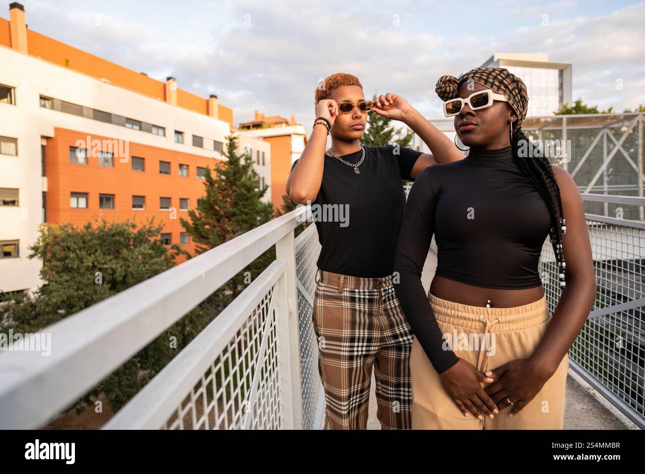 A fashionable LGBT multiethnic couple poses confidently on an urban ...