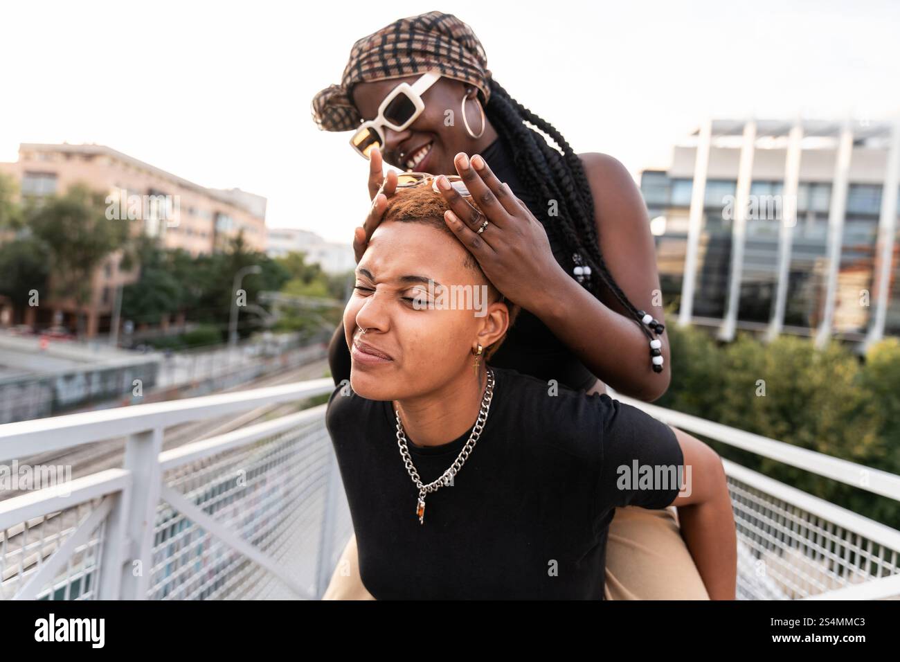 A joyful LGBT multiethnic couple shares playful moments outside. They ...