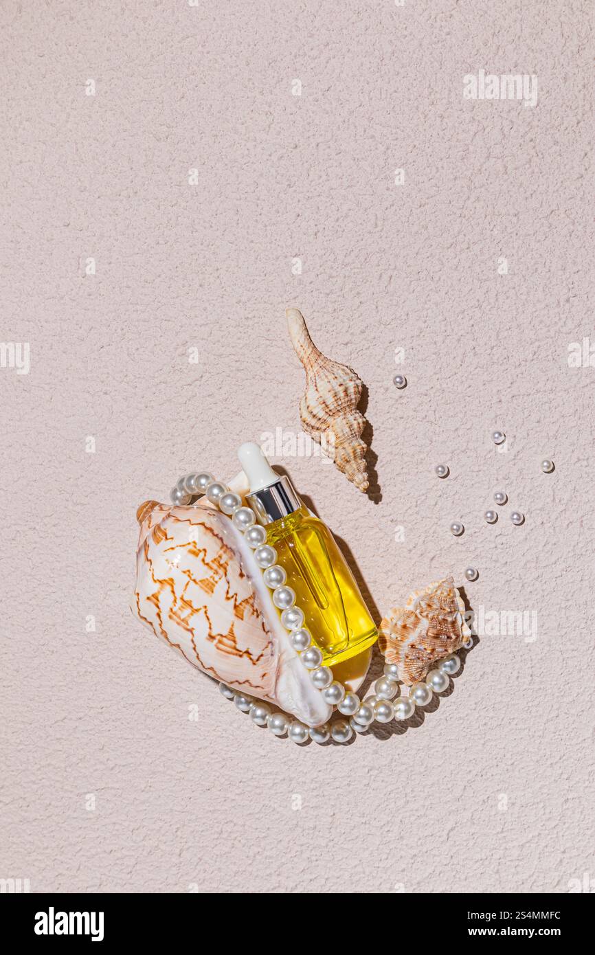 Aesthetic top view of seashells, a string of pearls, and a golden vial ...