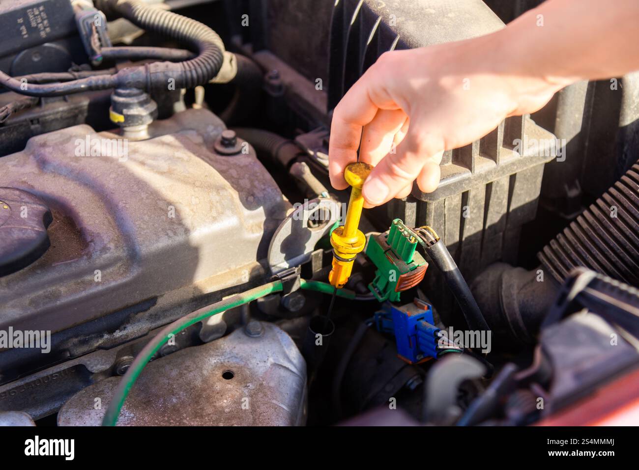 A person checks the oil level in a car engine after an accident ...