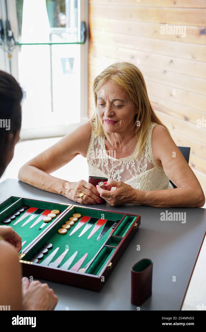 Mother plays backgammon with her daughter The scene captures a moment ...