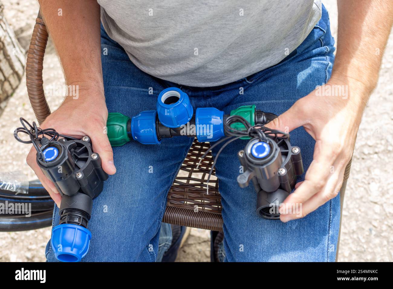 A man assembles a drip irrigation system by assembling pipeline ...