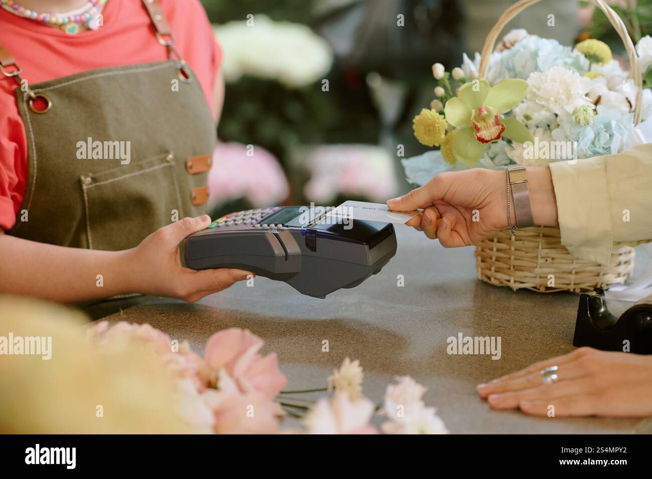 Medium close up of unrecognizable customers hand tapping card while ...