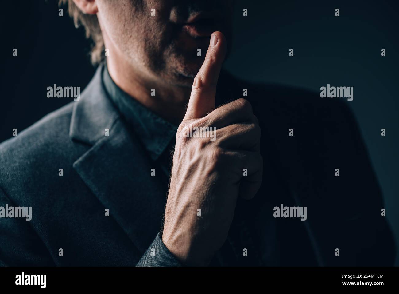 Businessman making a shh hand sign gesture, be quiet and keep the ...