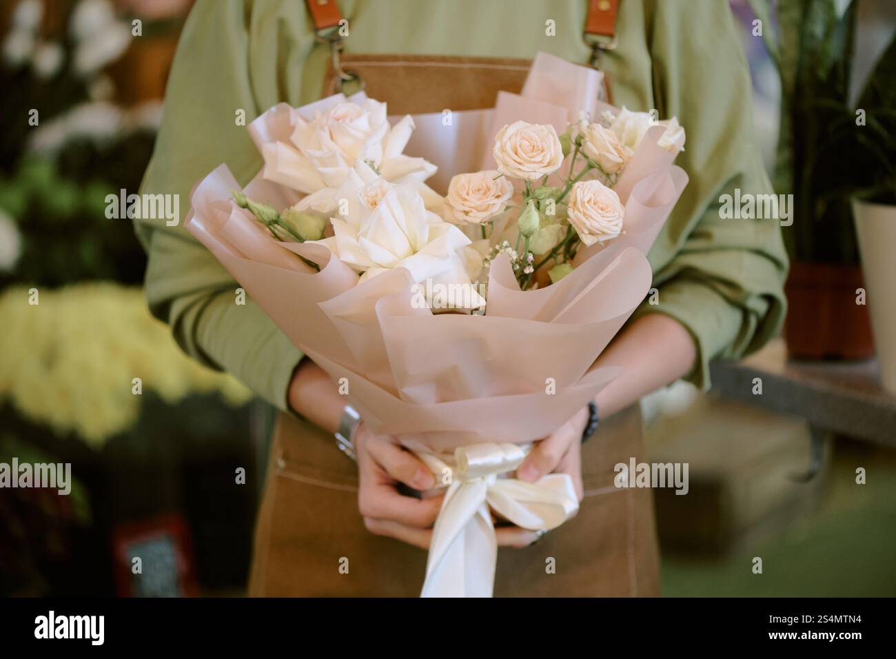Unrecognizable female hand holding pastel pink bouquet of different ...