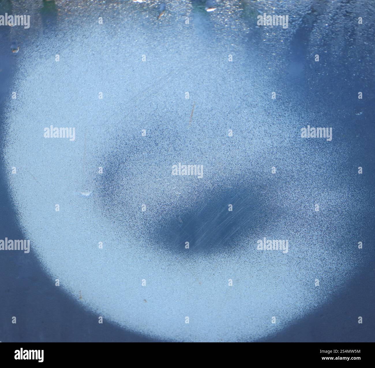 Macro, close up. A swirl of white ice on the glass window of a bus ...