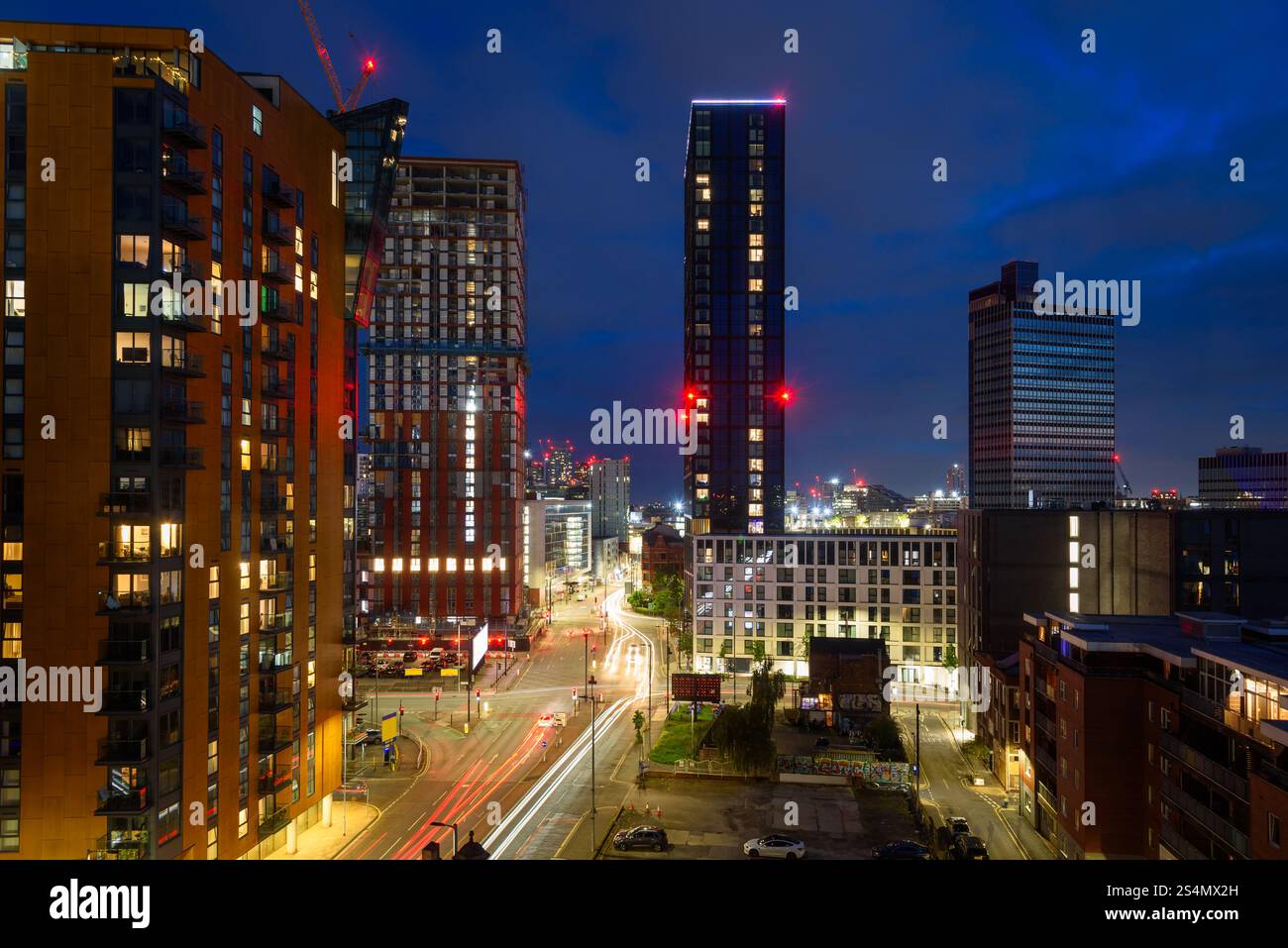 High rise apatment blocks along a busy street in Manchester at night ...