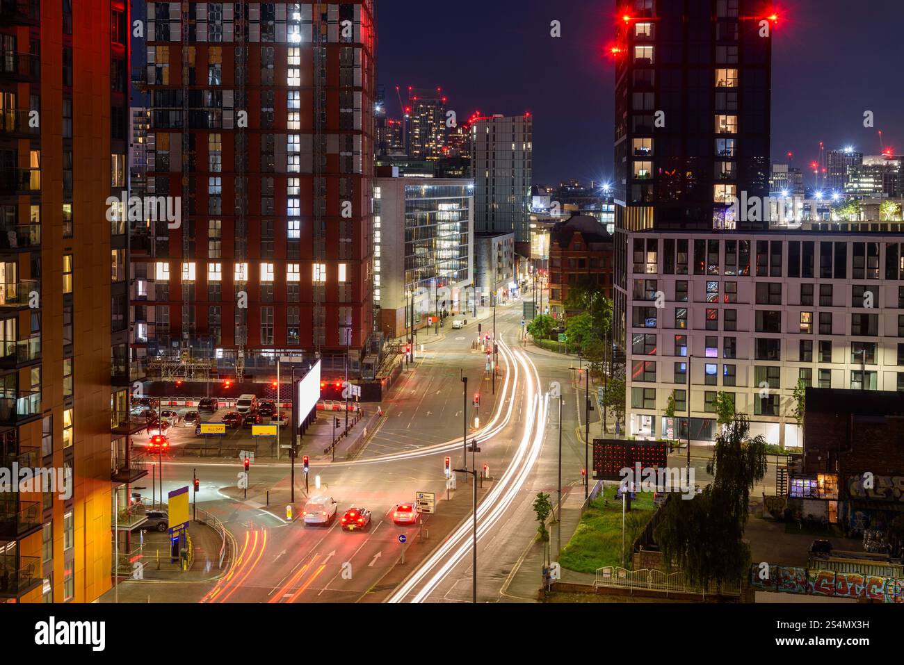 Busy crossroads in Manchester at night, Modern apartment towers ...