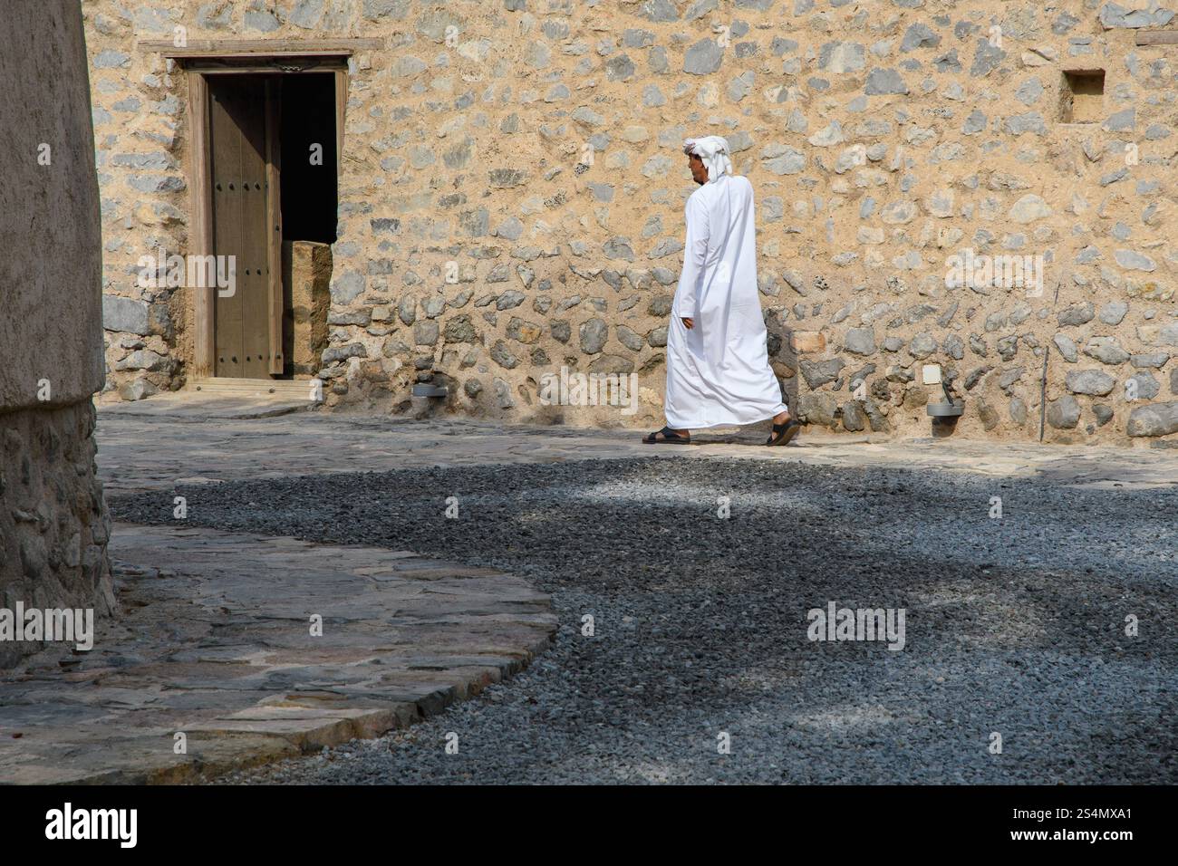 Khasab, Oman - January 1, 2025: A man in traditional attire walks ...