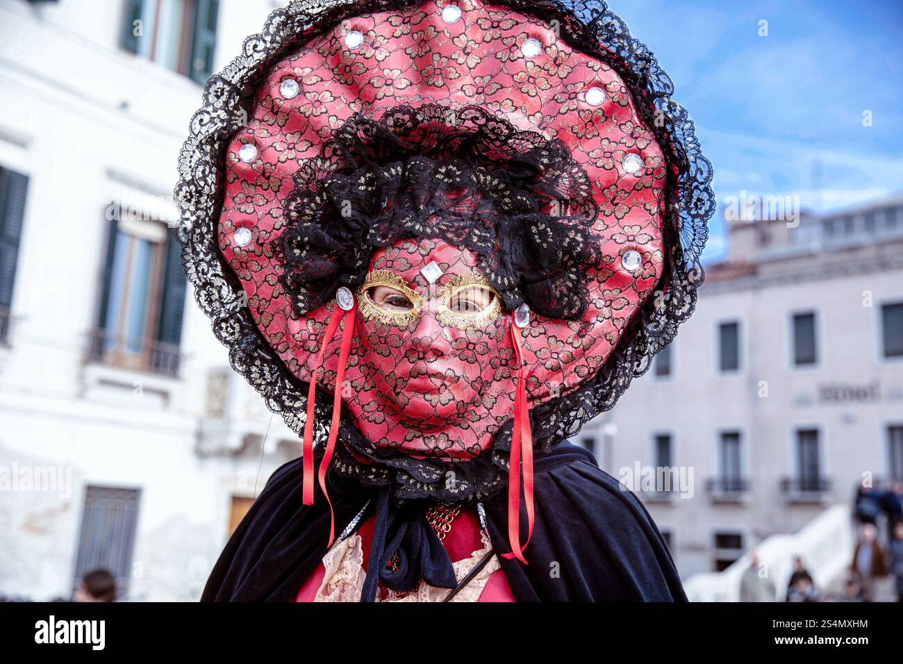 Venetian masked figure in red lace costume at outdoor event Stock Photo ...