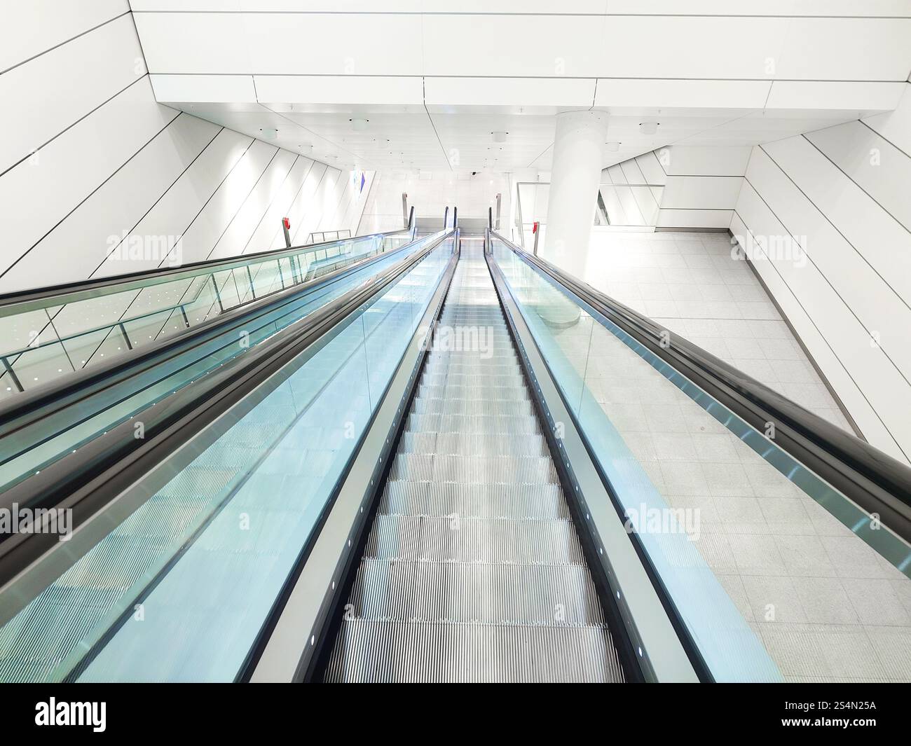 Empty long descending rolling stairs inside modern underground building ...