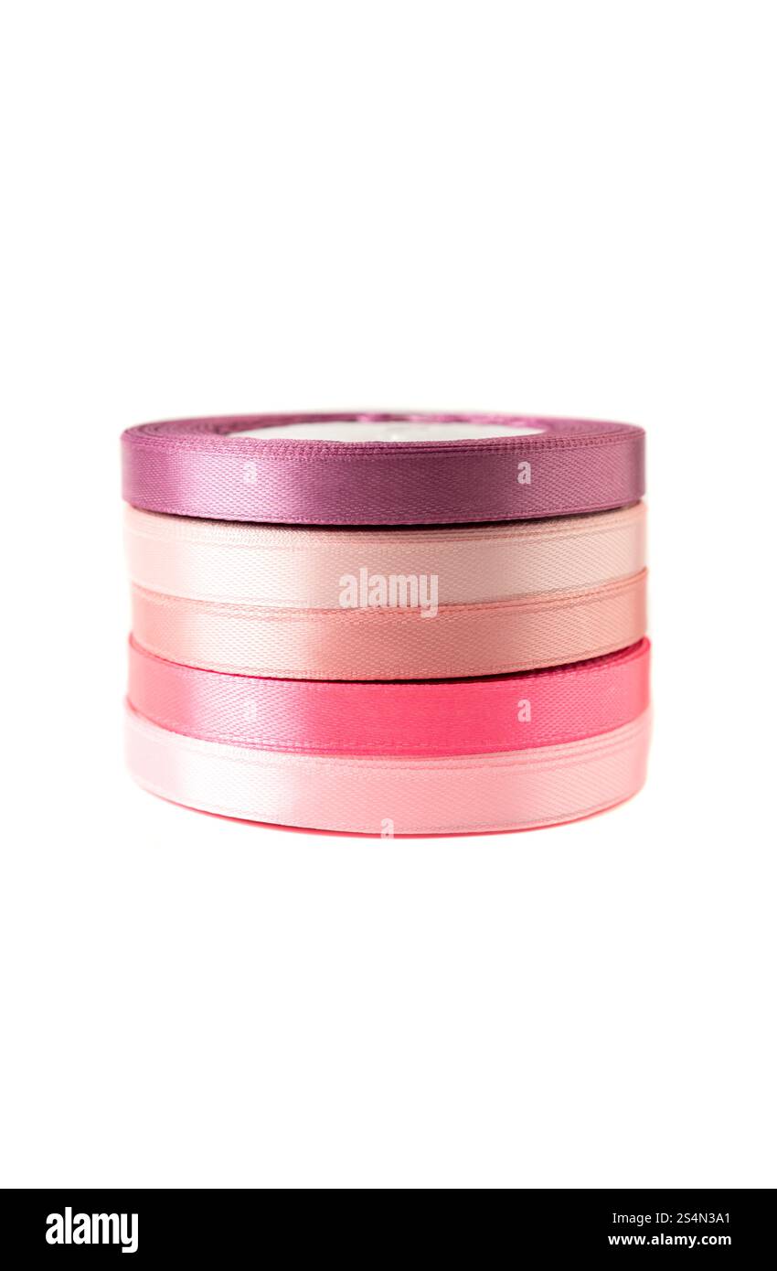 stack of satin ribbons in shades of pink against a white background ...