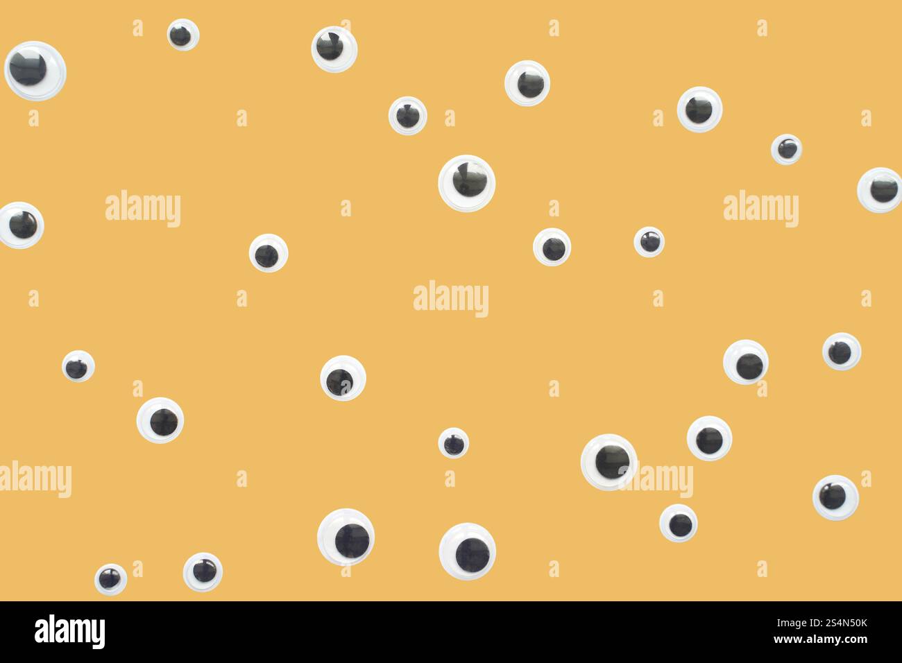 Scattered googly eyes on yellow background with playful and creative ...