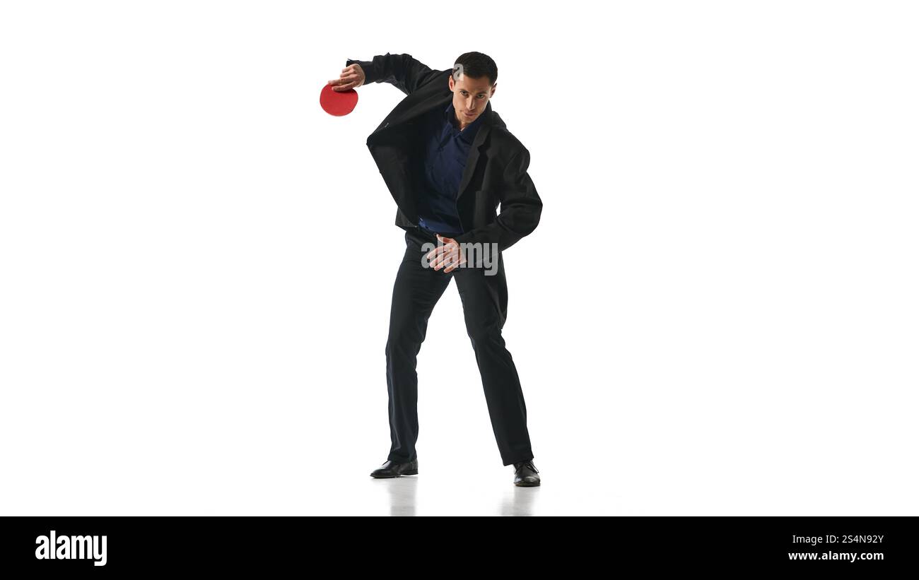 Man in black suit holding red ping-pong paddle in dynamic stance ...