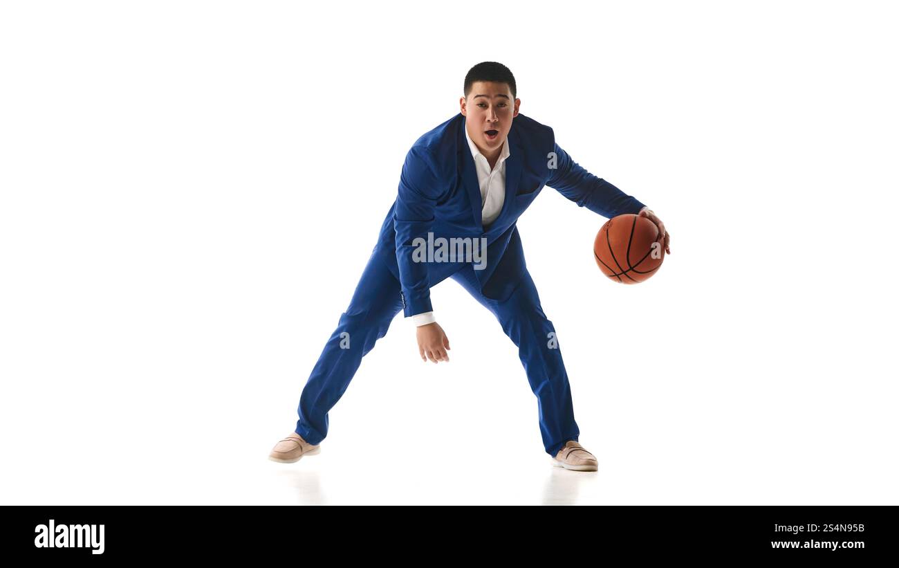 Man in blue suit holding basketball in athletic stance, representing ...
