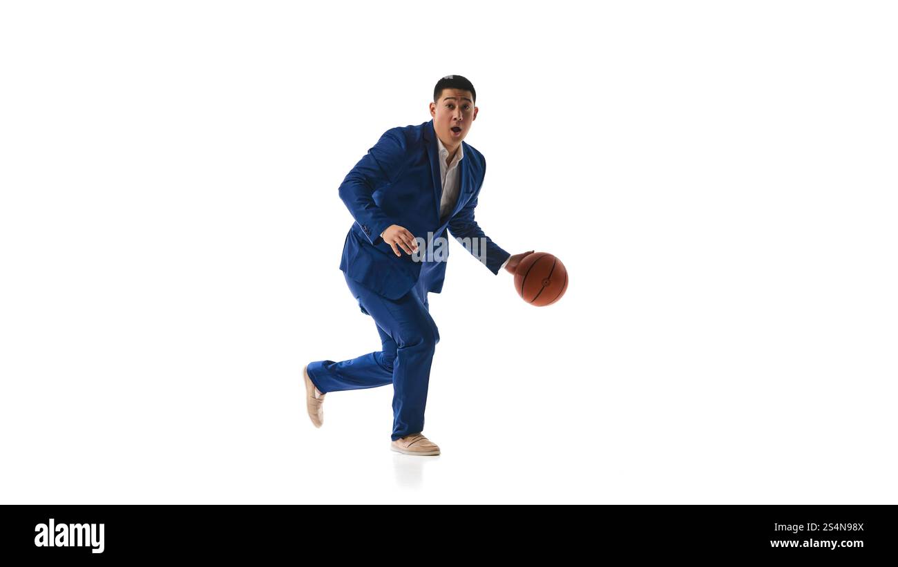 Man in blue suit running with basketball in active motion, reflecting ...