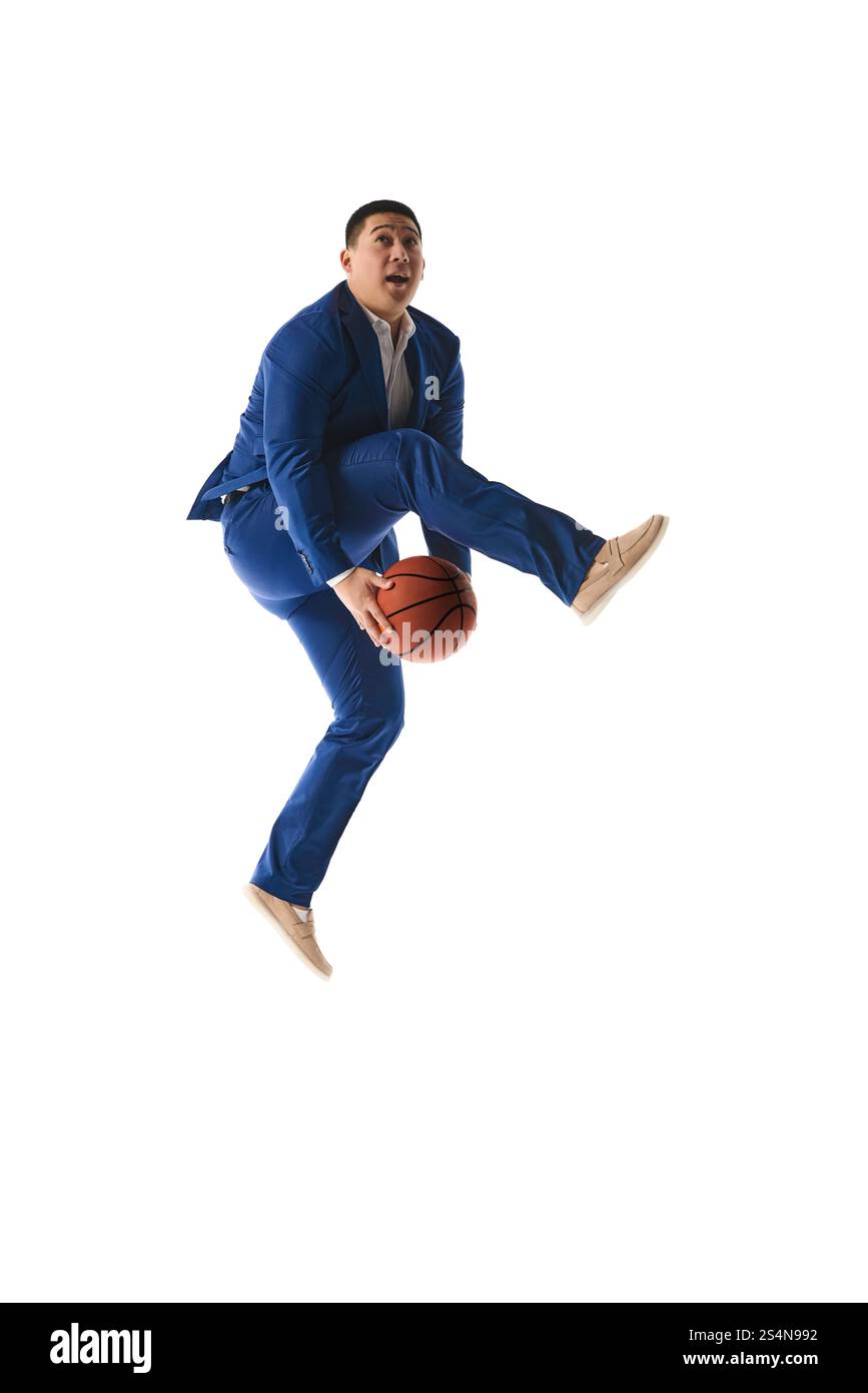 Man in blue suit mid-jump holding basketball with confident expression ...