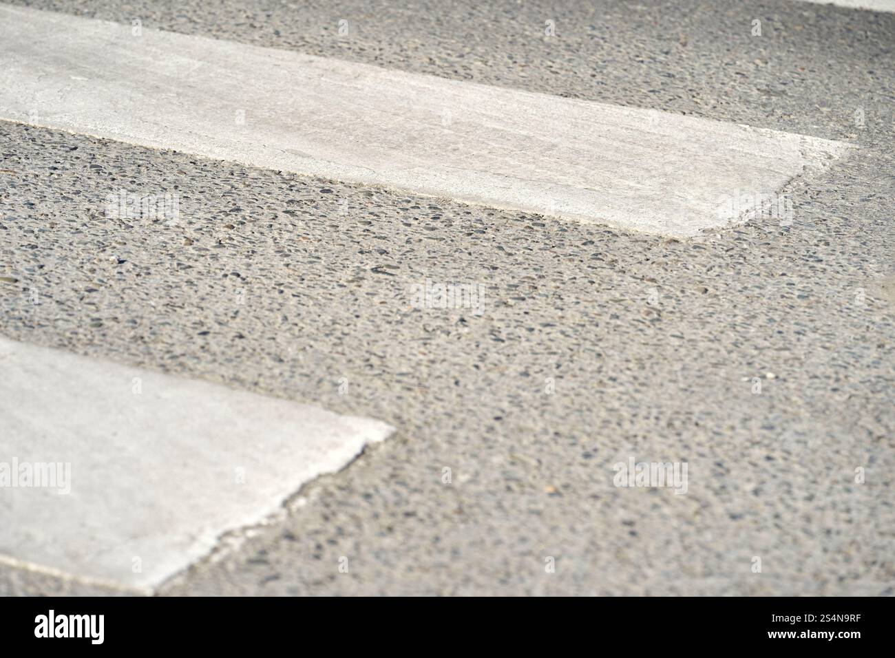 Close up of pedestrian crosswalk markings on asphalt road surface with ...