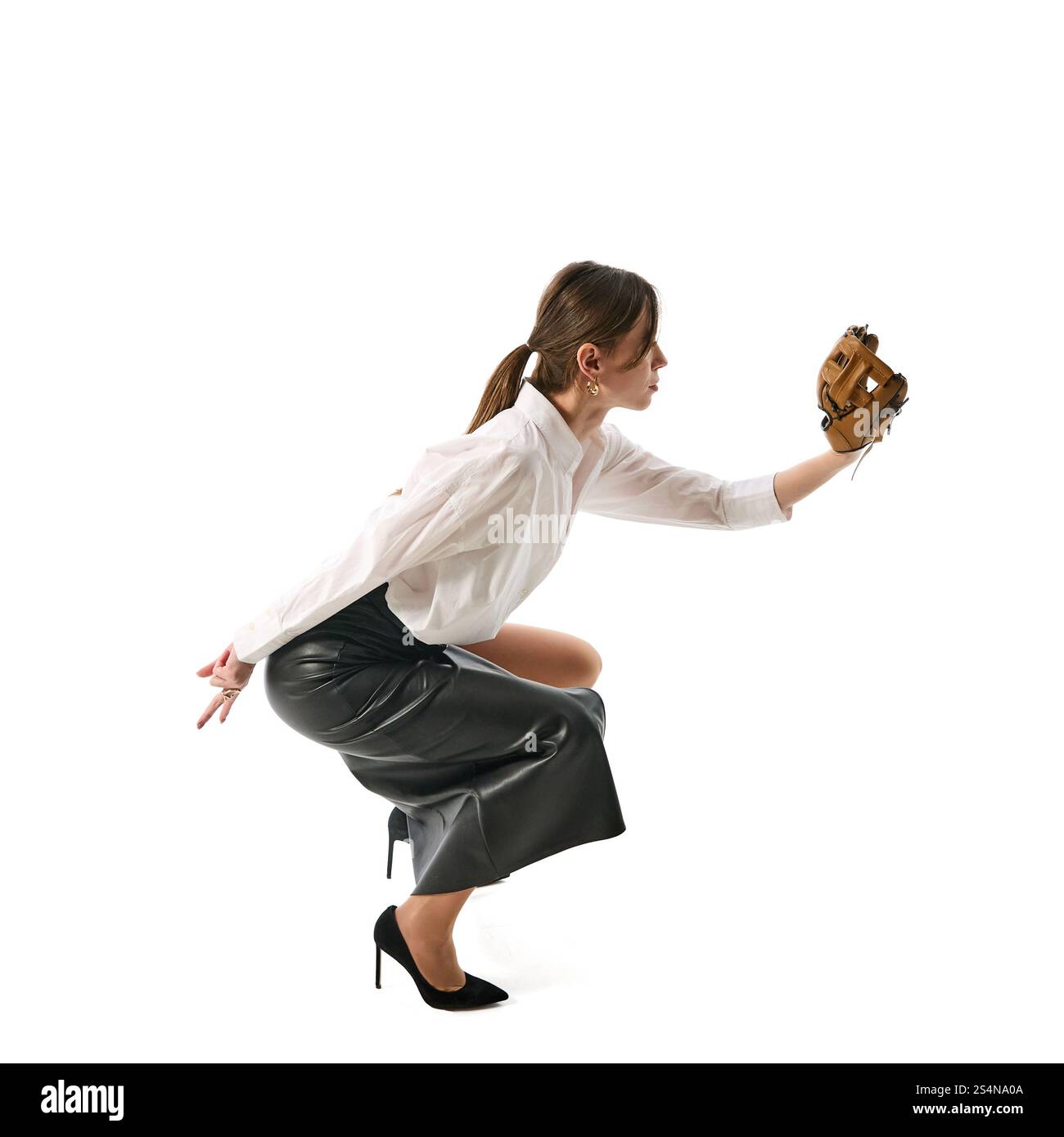 Woman crouched with baseball glove, reaching forward, portraying focus ...