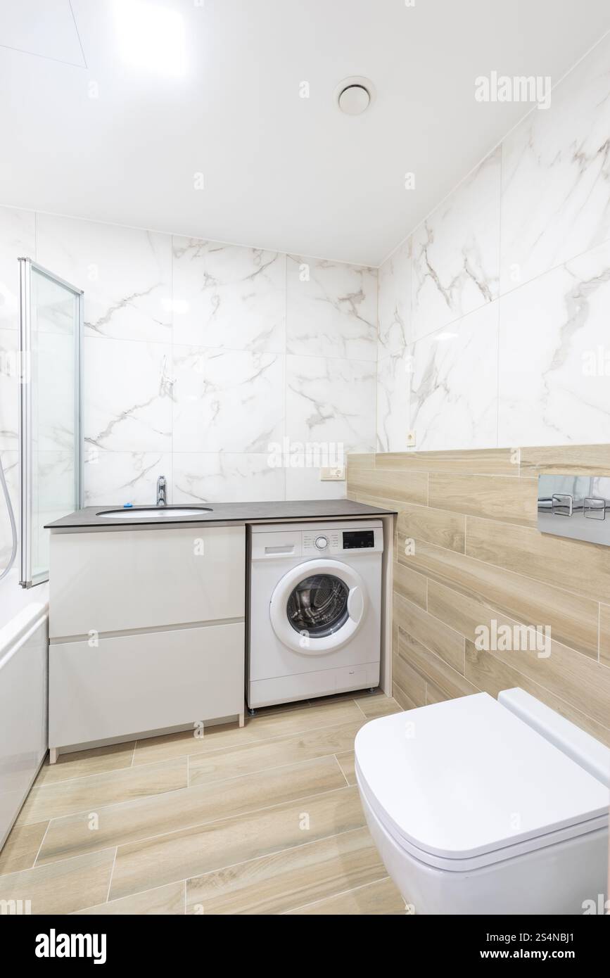 Bright and contemporary bathroom featuring a washing machine, sleek ...