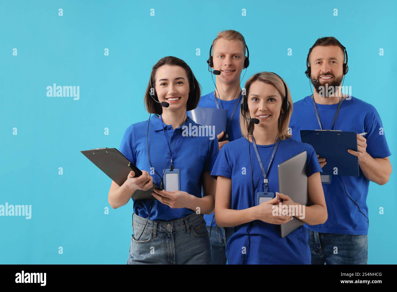 Technical support call center. Team of friendly operators on light blue ...